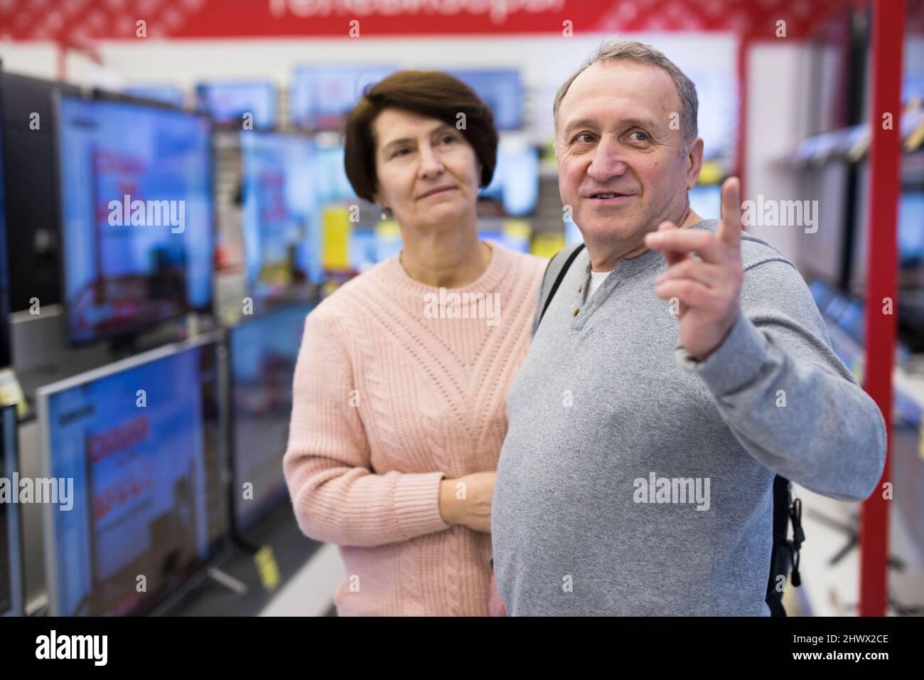 Middle aged man and woman choosing TV in electronic store Stock Photo ...