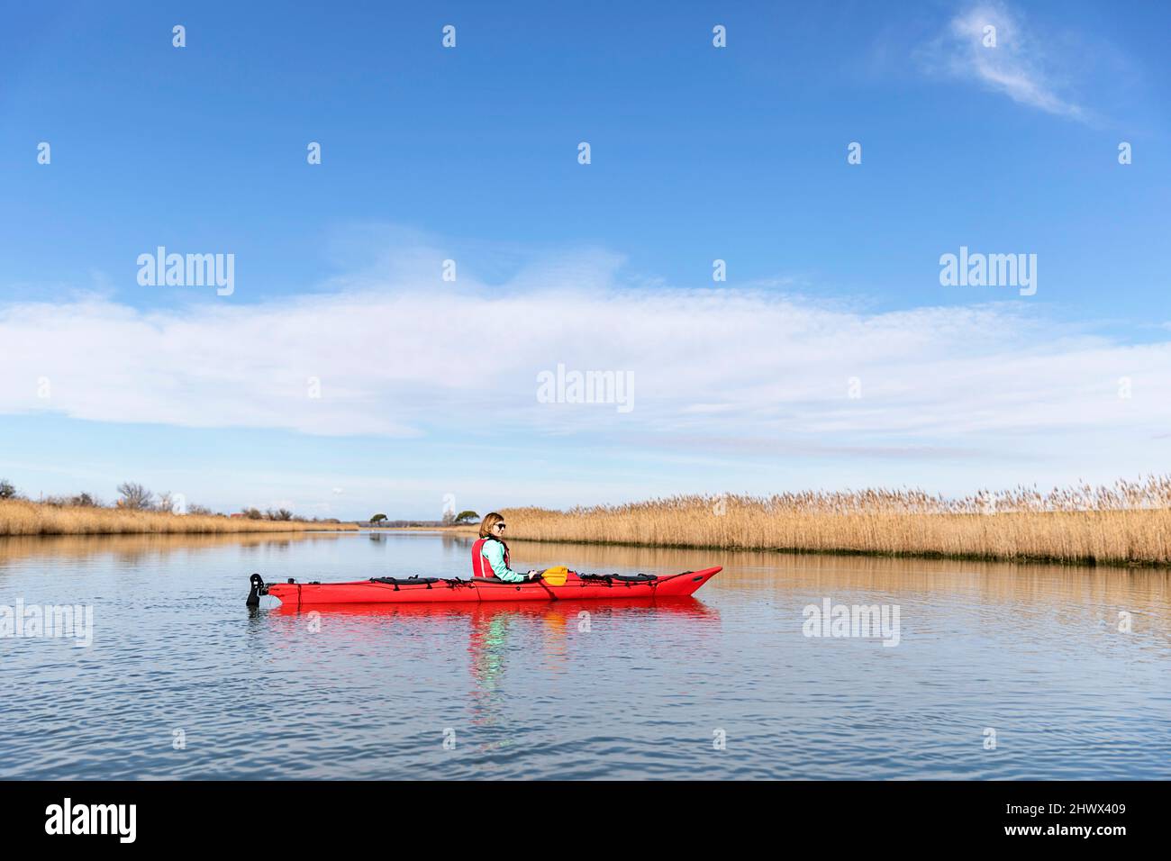 Woman by sea kayak explorign Isonzo river's mouth (Soča river ...