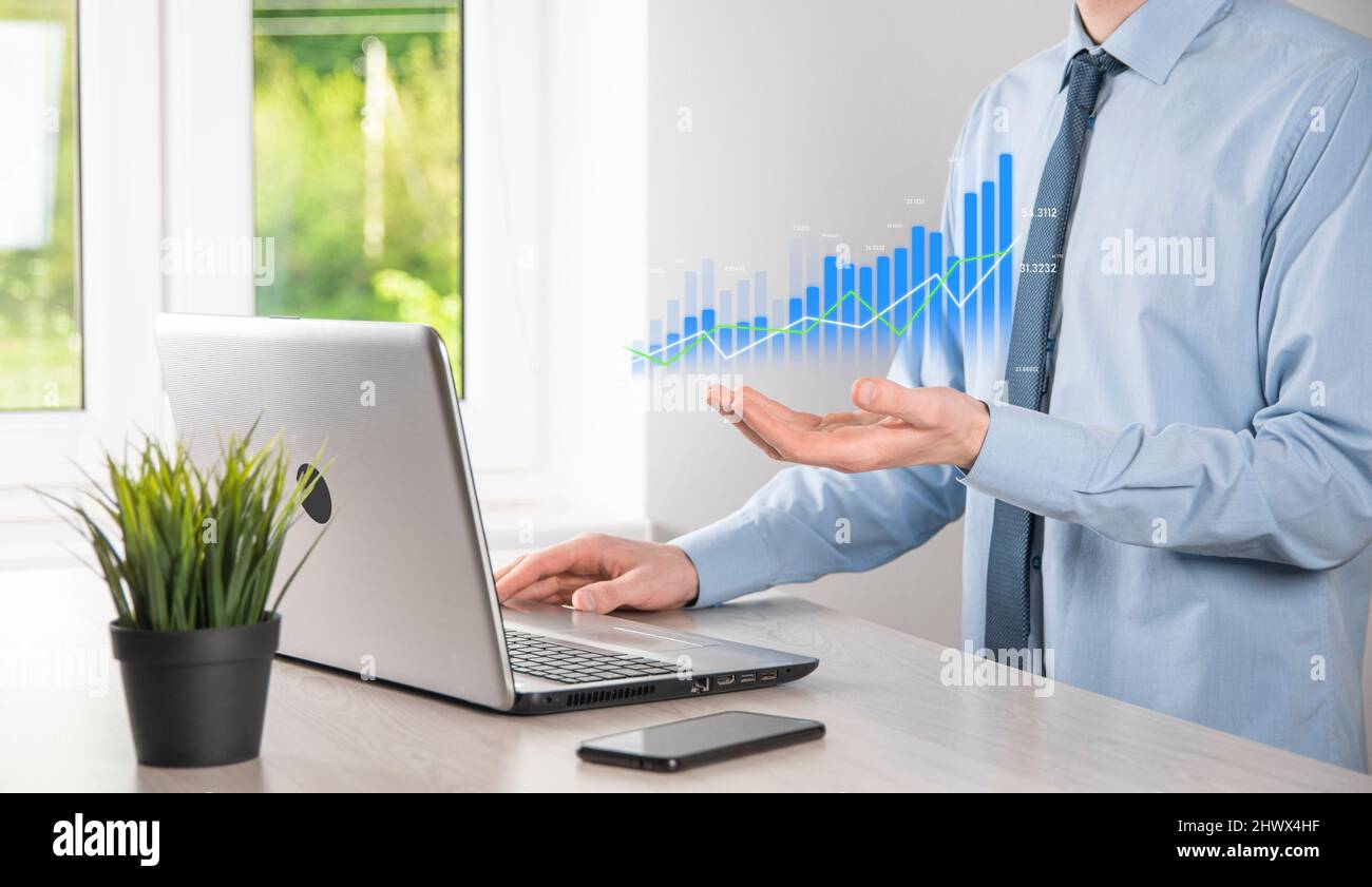 Business man holding tablet and showing holographic graphs and stock ...