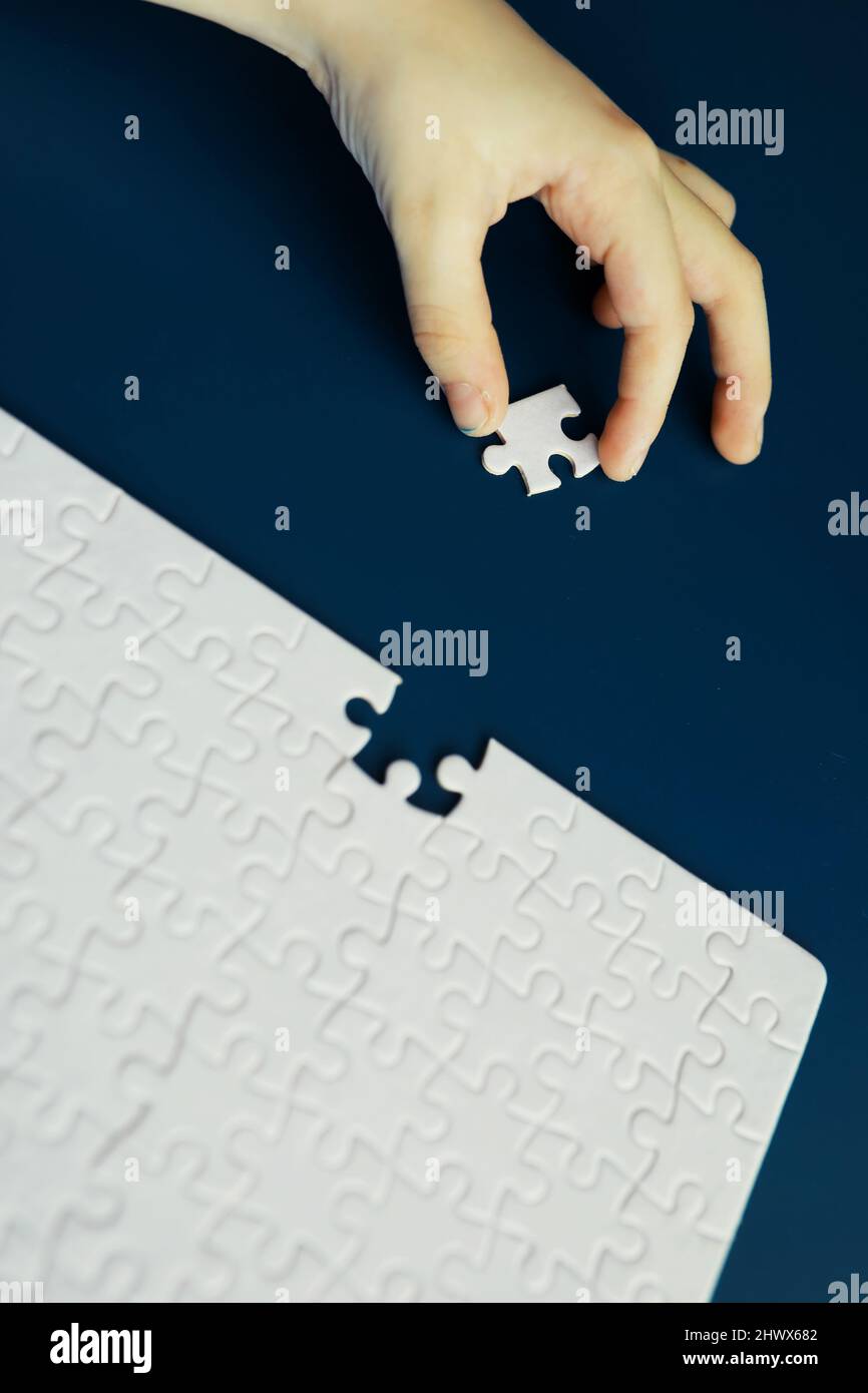 Intellectual puzzles. The puzzle empty. The hand puts together puzzle ...