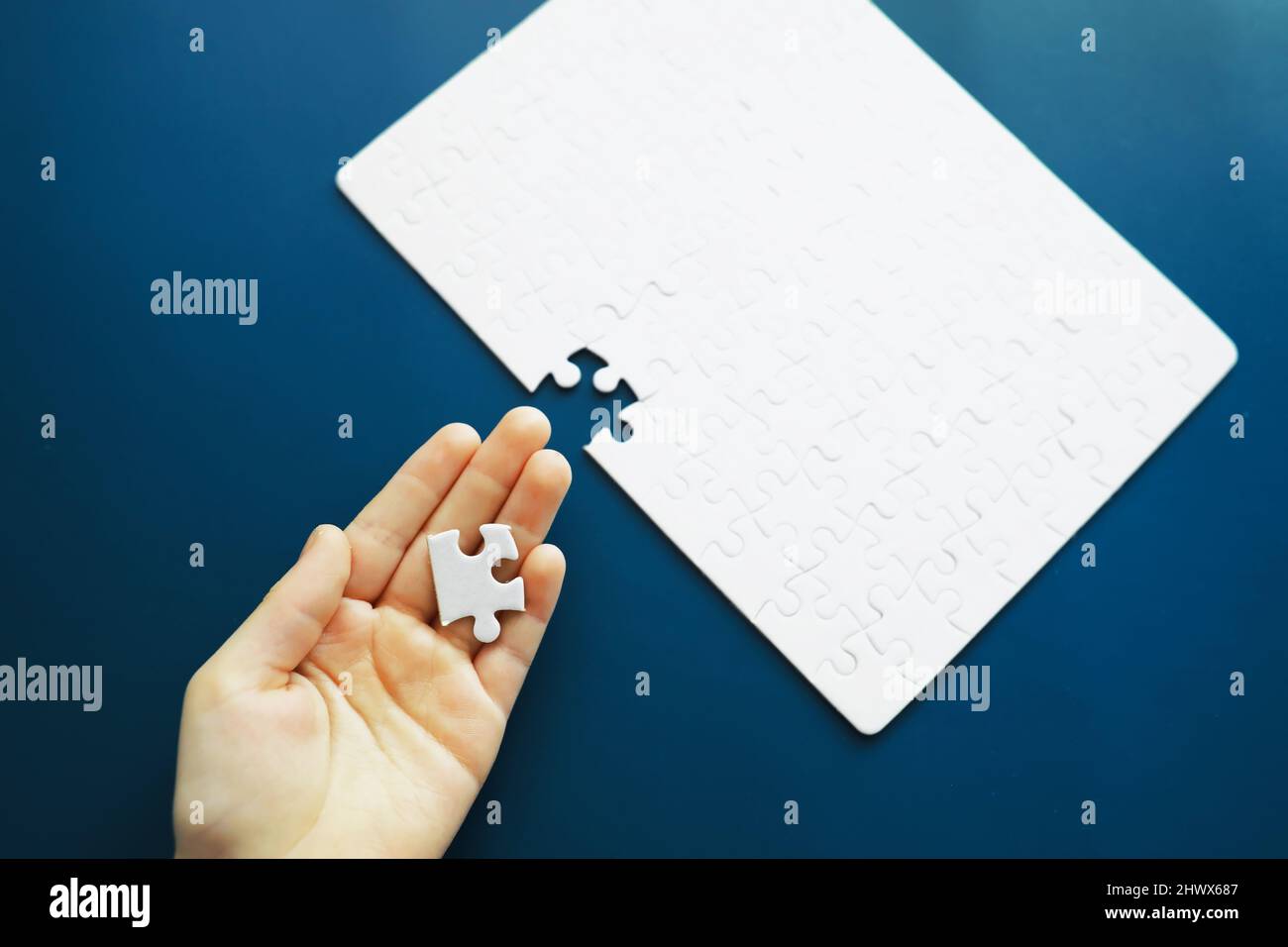 Intellectual puzzles. The puzzle empty. The hand puts together puzzle ...