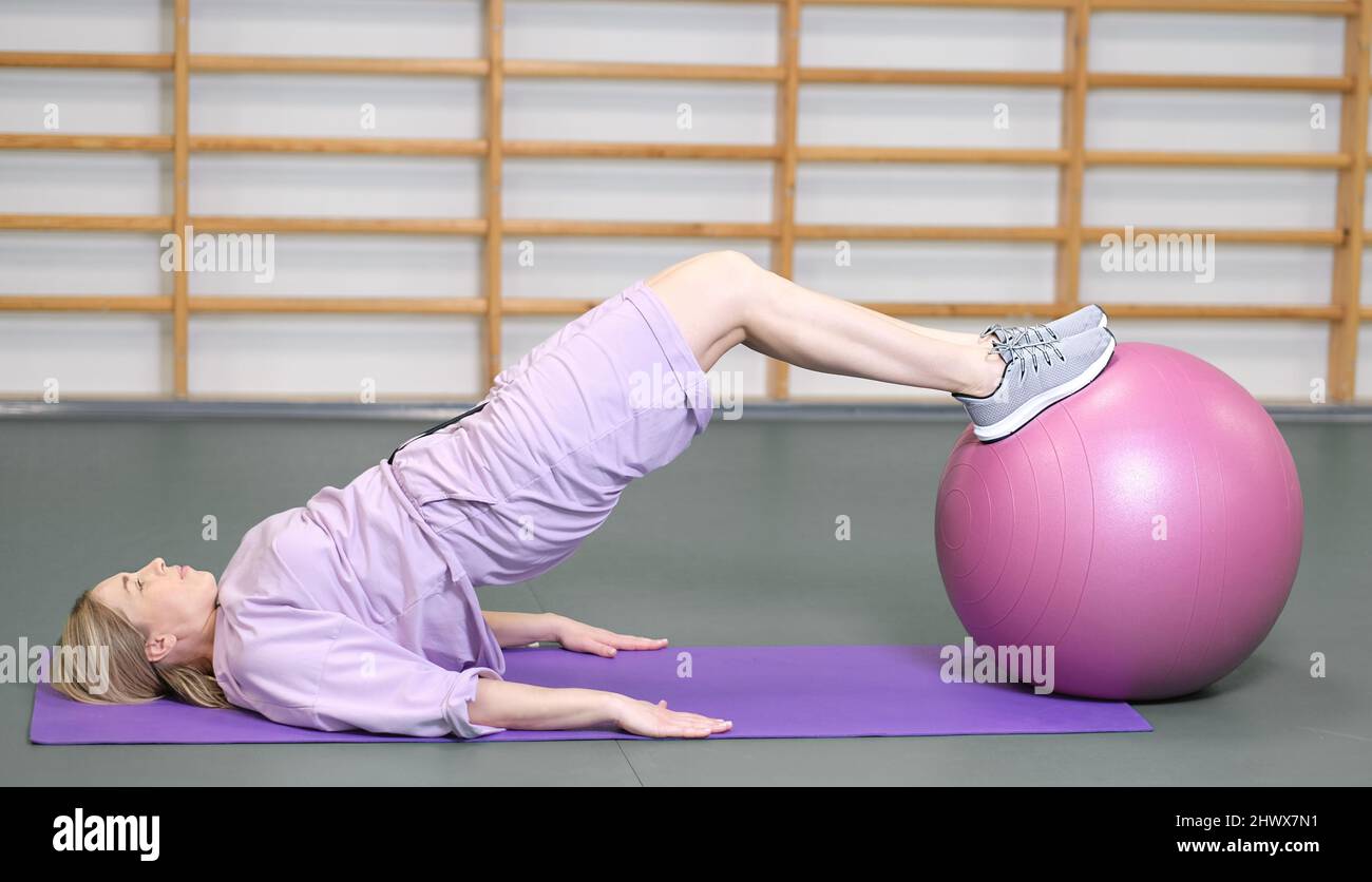 woman doing bridge using fitball in a fitness club. pilates workout ...