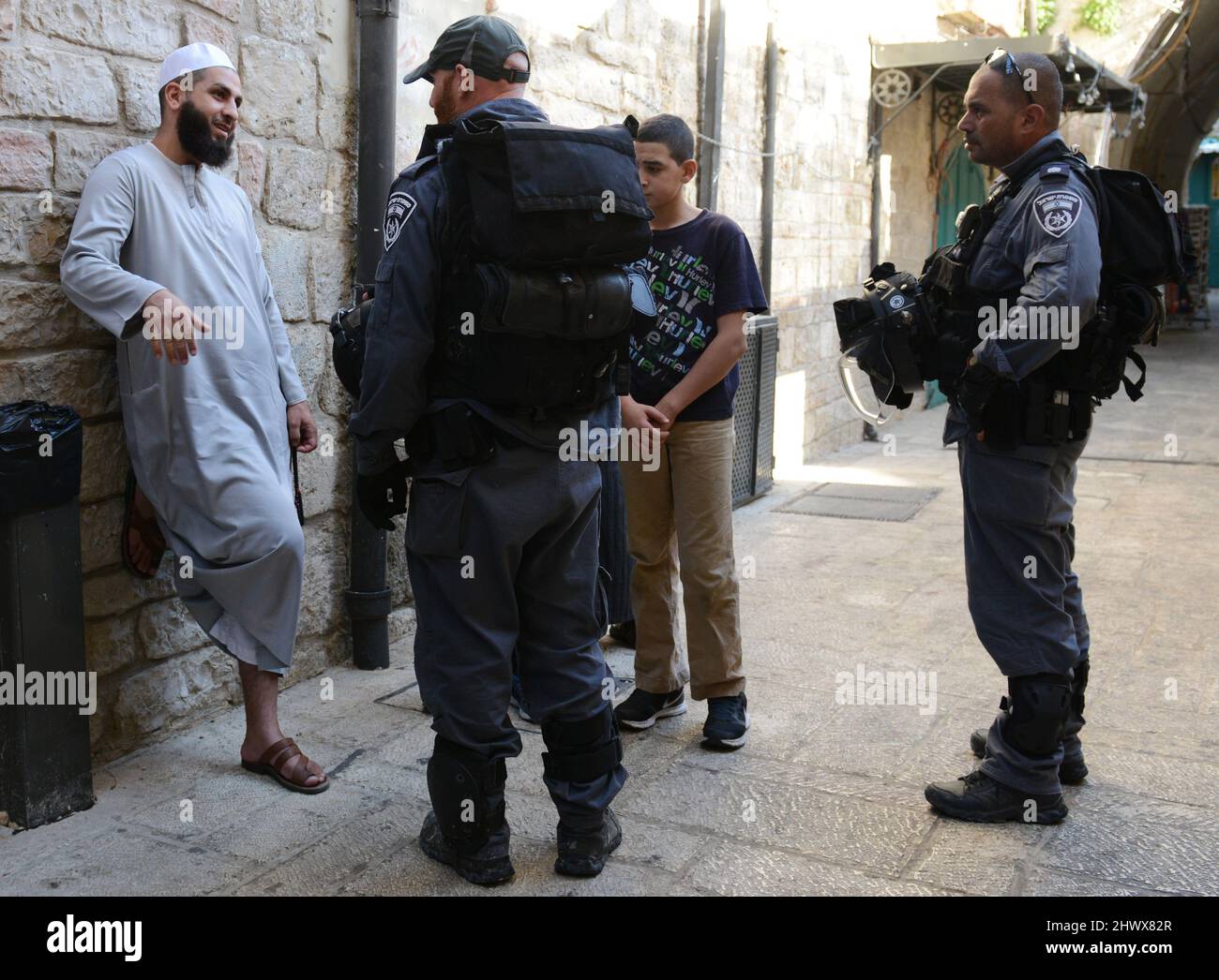 An Israeli border policeman talking to a Palestinian man in the Muslim ...