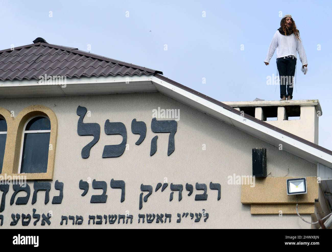 A young Jewish Breslov devotee praying on top of the tomb praying hall ...