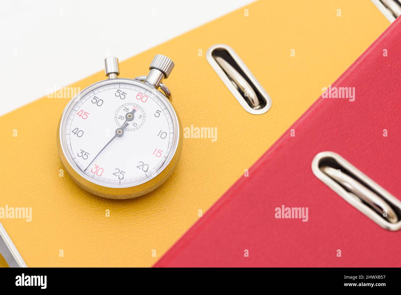 Yellow office folder on the chronometer Stock Photo - Alamy