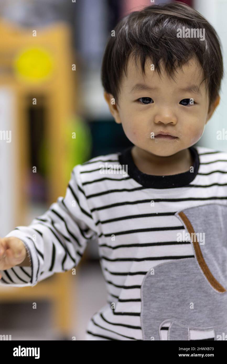 Portrait image of Adorable and happy Chinese baby boy child relaxing in ...