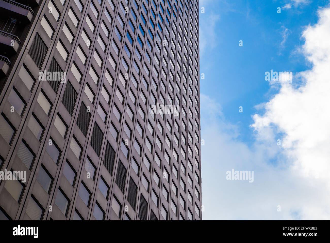 Window office building in Tokyo city against blue sky with cloud uprise ...