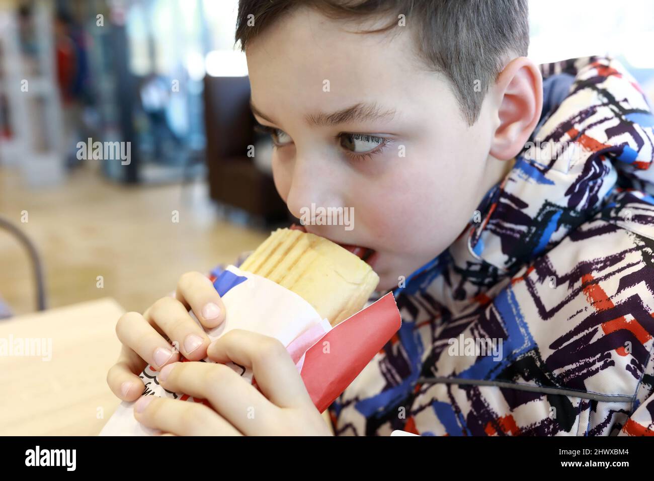 Child eating hot dog in a restaurant Stock Photo - Alamy