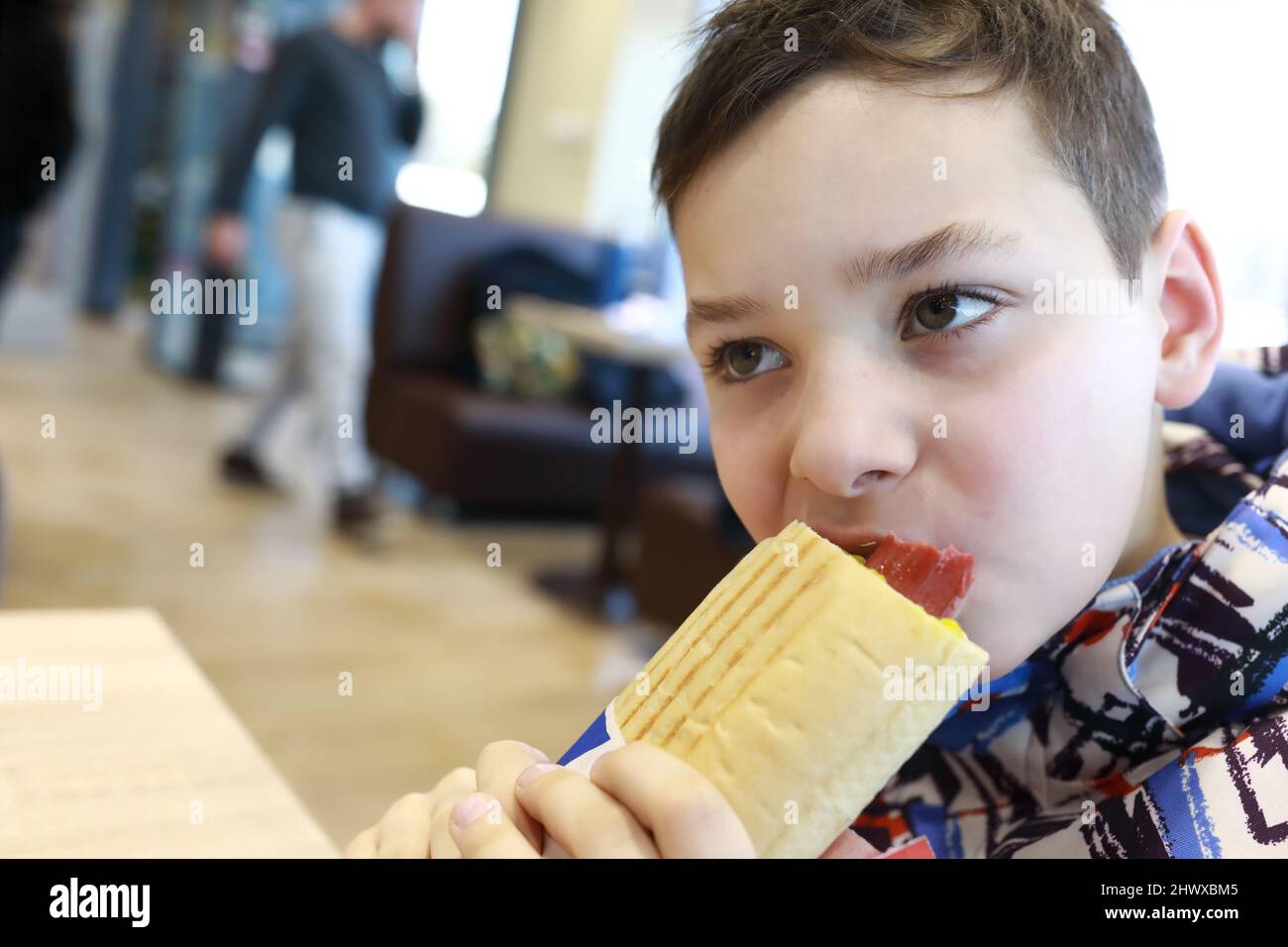 Kid eating hot dog in a restaurant Stock Photo - Alamy