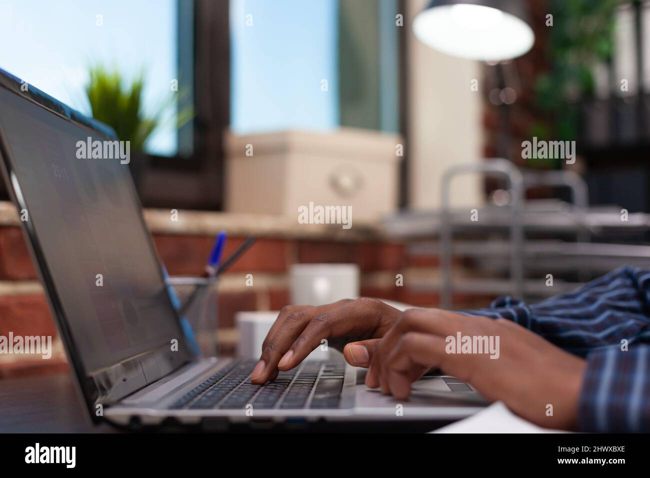 Focus on startup employee hands typing business data on laptop keyboard ...