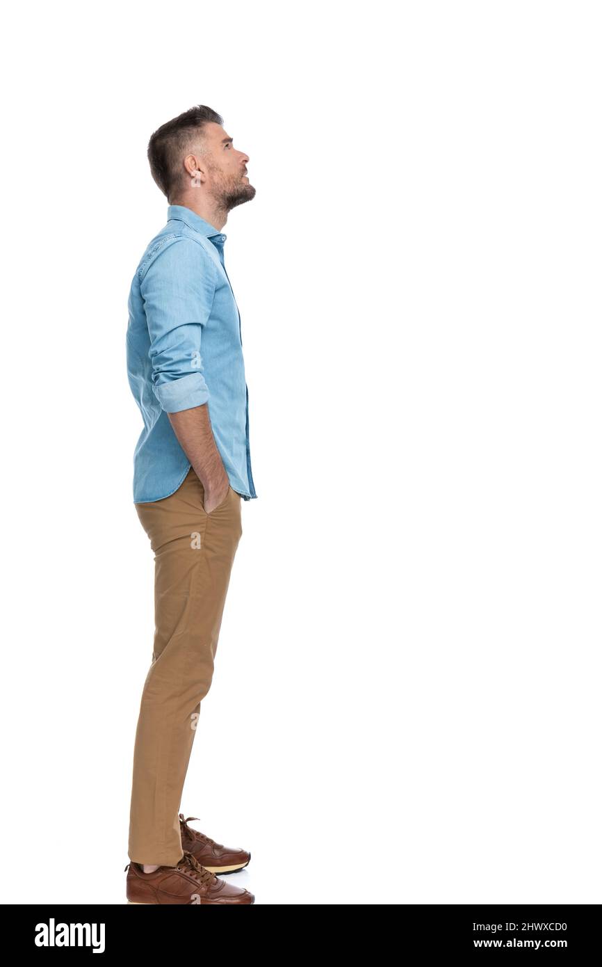 attractive man in his forties standing in line with hands in pockets ...