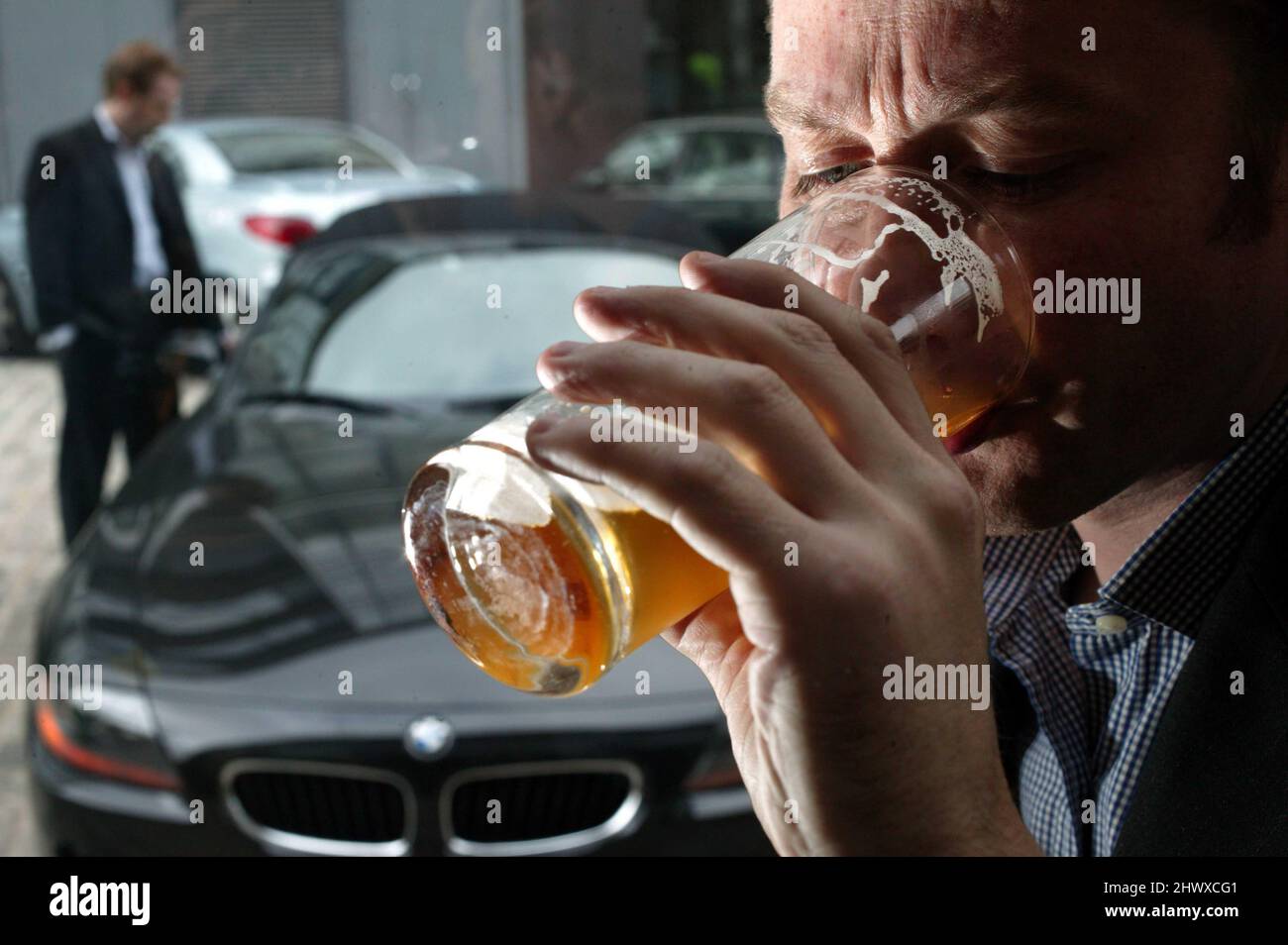 Man drinking beer in front of car. (MODEL RELEASED Stock Photo - Alamy