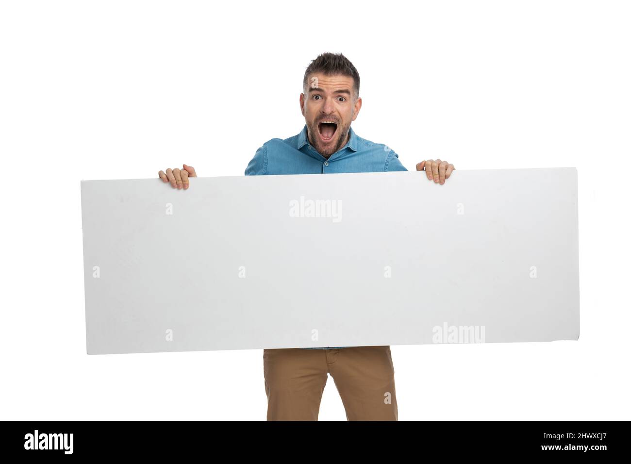 shocked casual guy with long white billboard in hands being surprised ...