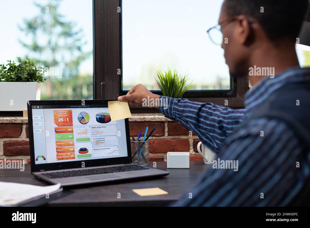 Office worker with glasses leaving reminder message sticker on corner ...