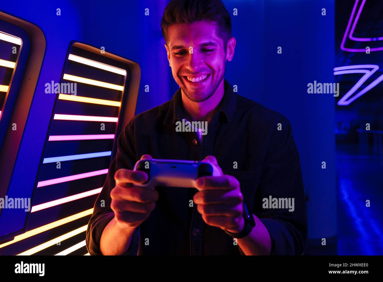 Young bristle man laughing while playing video game with joystick ...