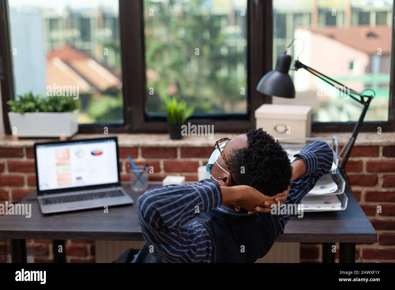 Tired startup business owner stretching and taking a break from working ...