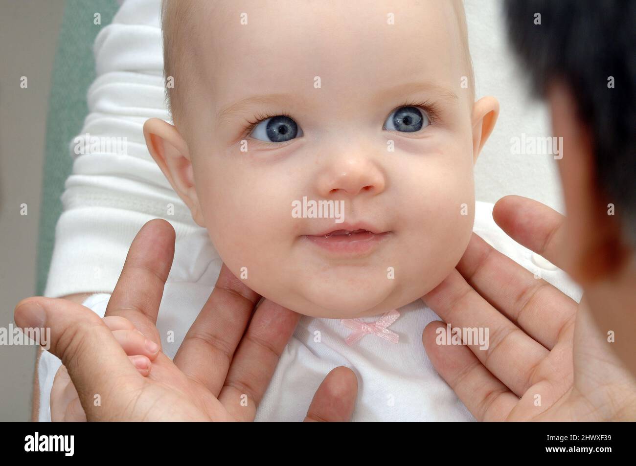 A GP checks a baby's neck for swollen glands(MODEL RELEASED Stock Photo ...