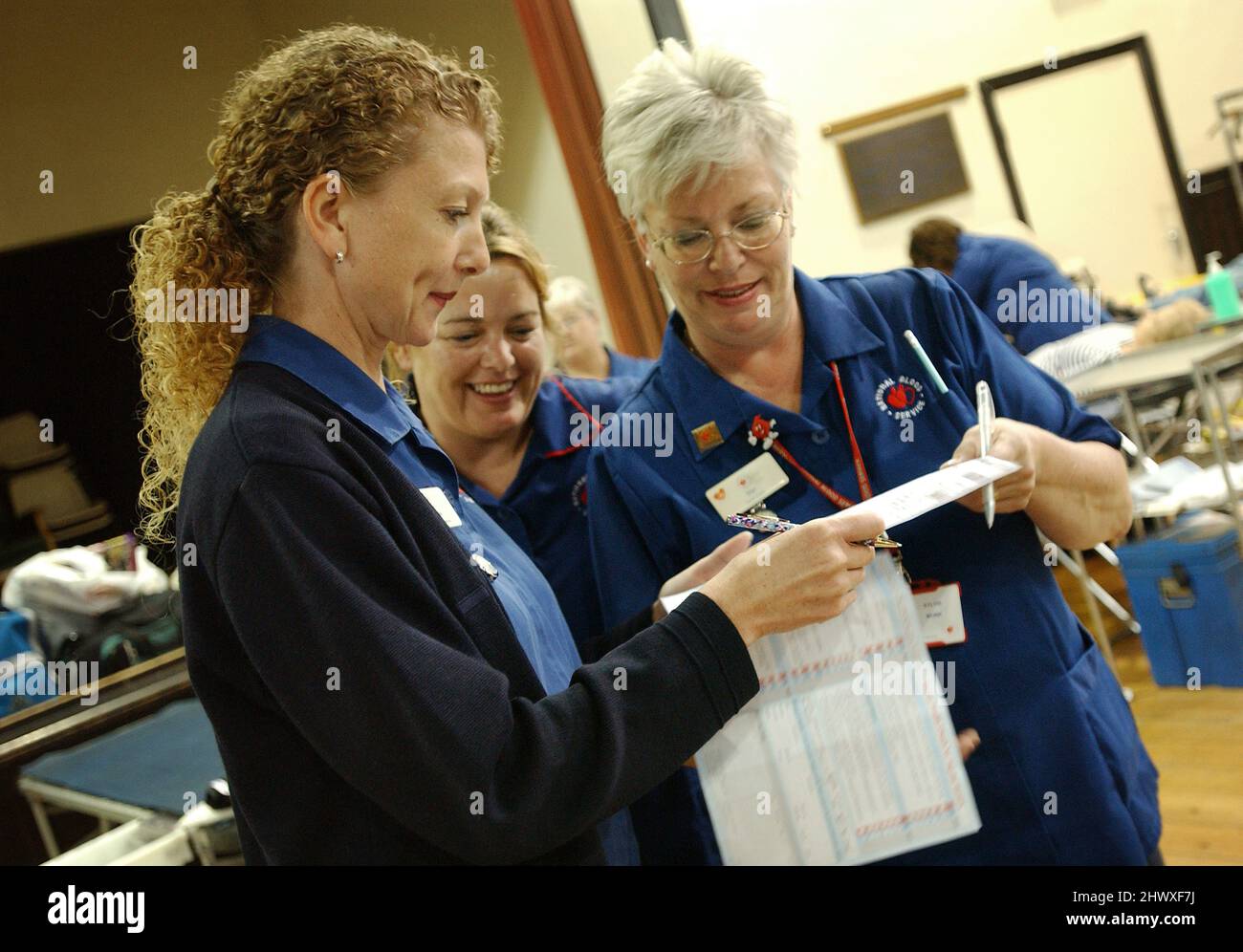 Three NHS National Blood Service nurses in blue uniforms check donor ...