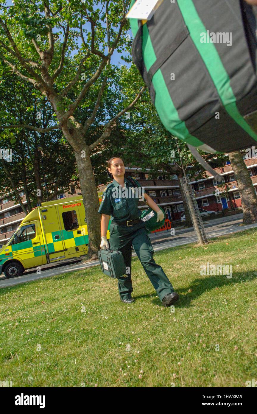 Paramedic carrying a bag of medical equipment towards an emergency ...