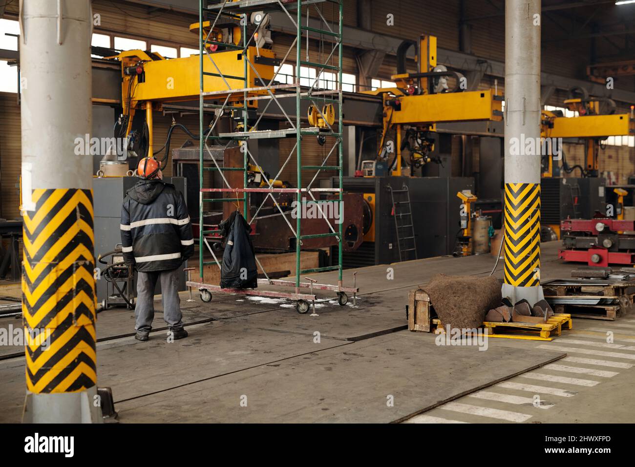 Worker of large industrial plant standing in front of technical ...