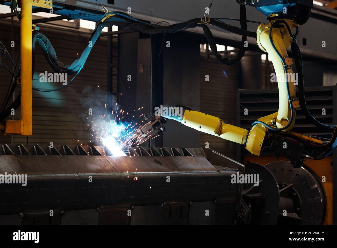 Arc welding of part of huge iron industrial automated machine during ...
