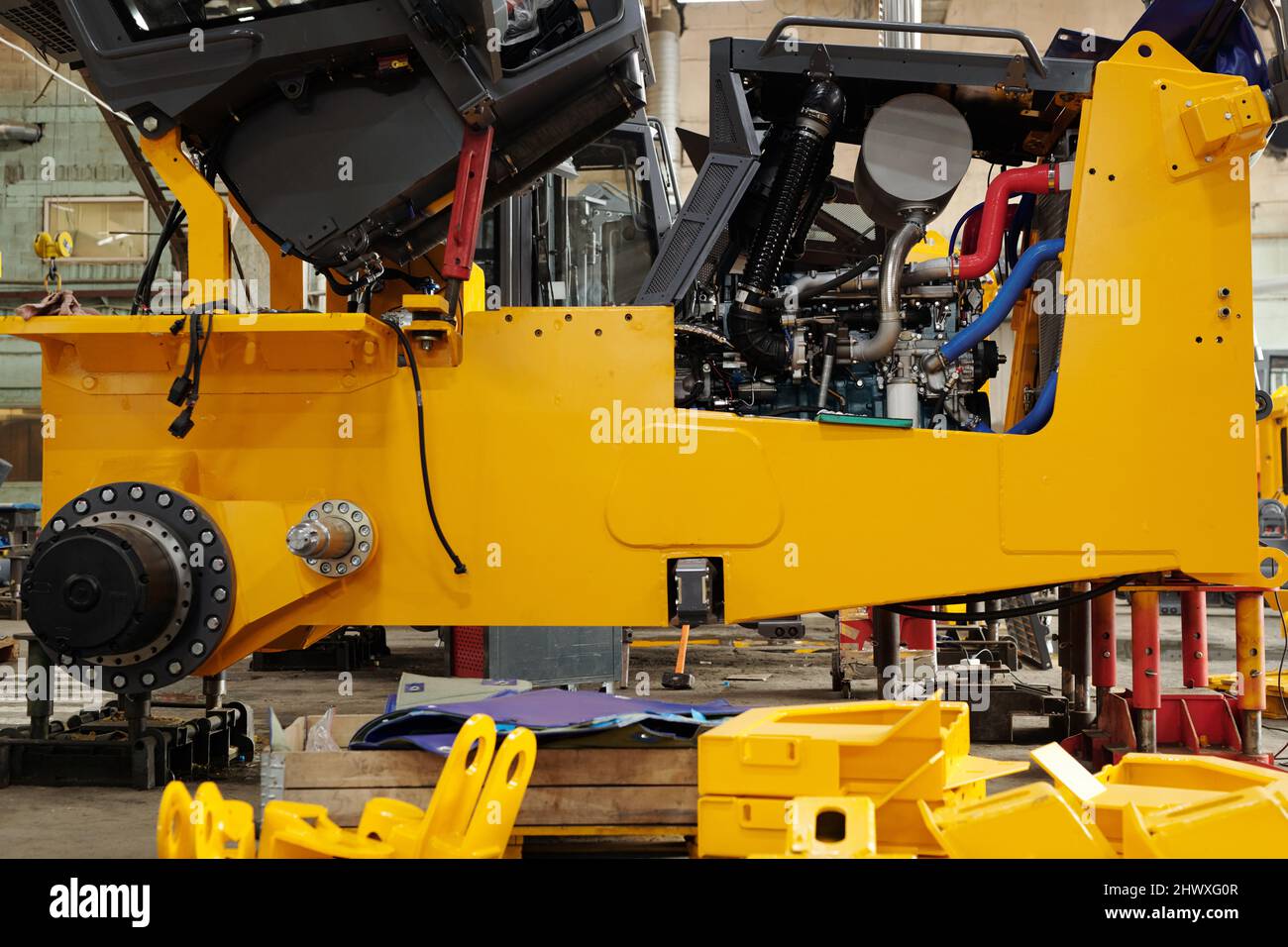 Side view of huge industrial machine of yellow color with open engine ...