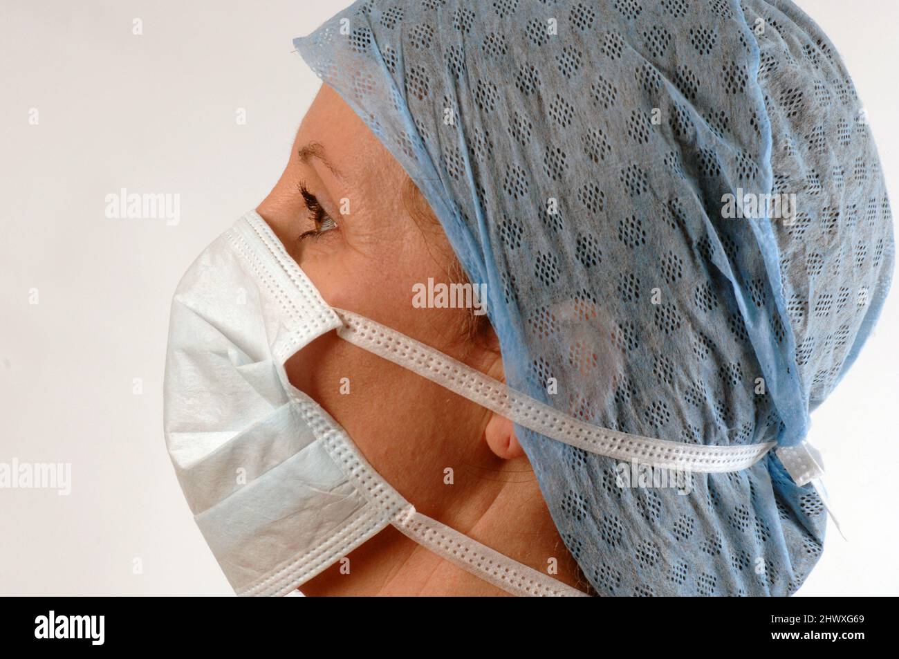 Facial close up of a hospital worker's hygiene mask and hat covered ...
