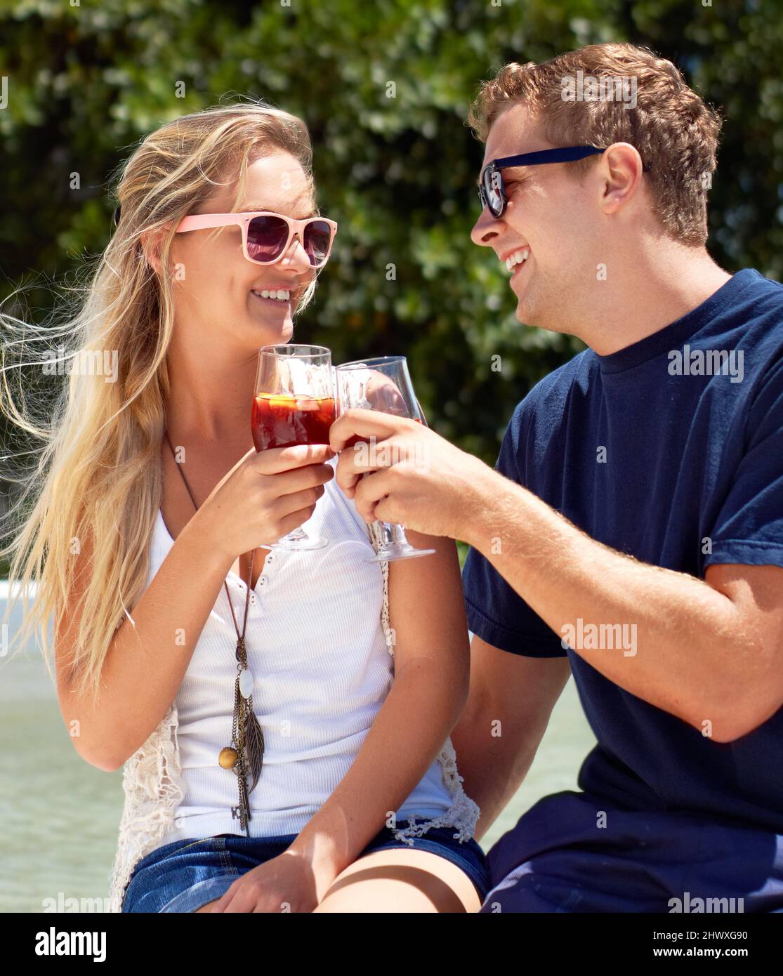 To us. A young couple toast each other on a summers day Stock Photo - Alamy