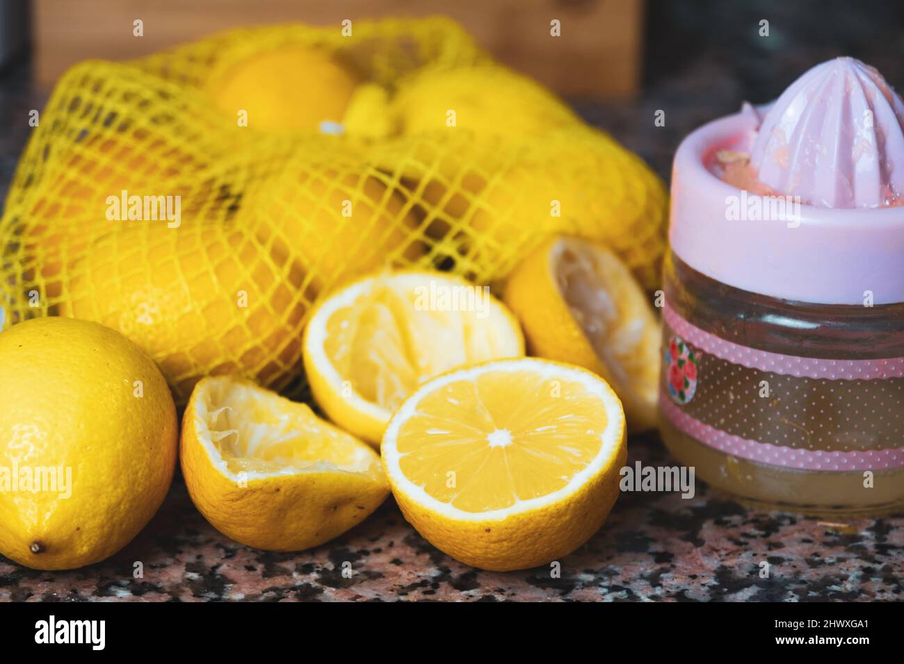 Lemon stack and juicer or squeezer on kitchen countertop. No sugar, sugar free delicious ...