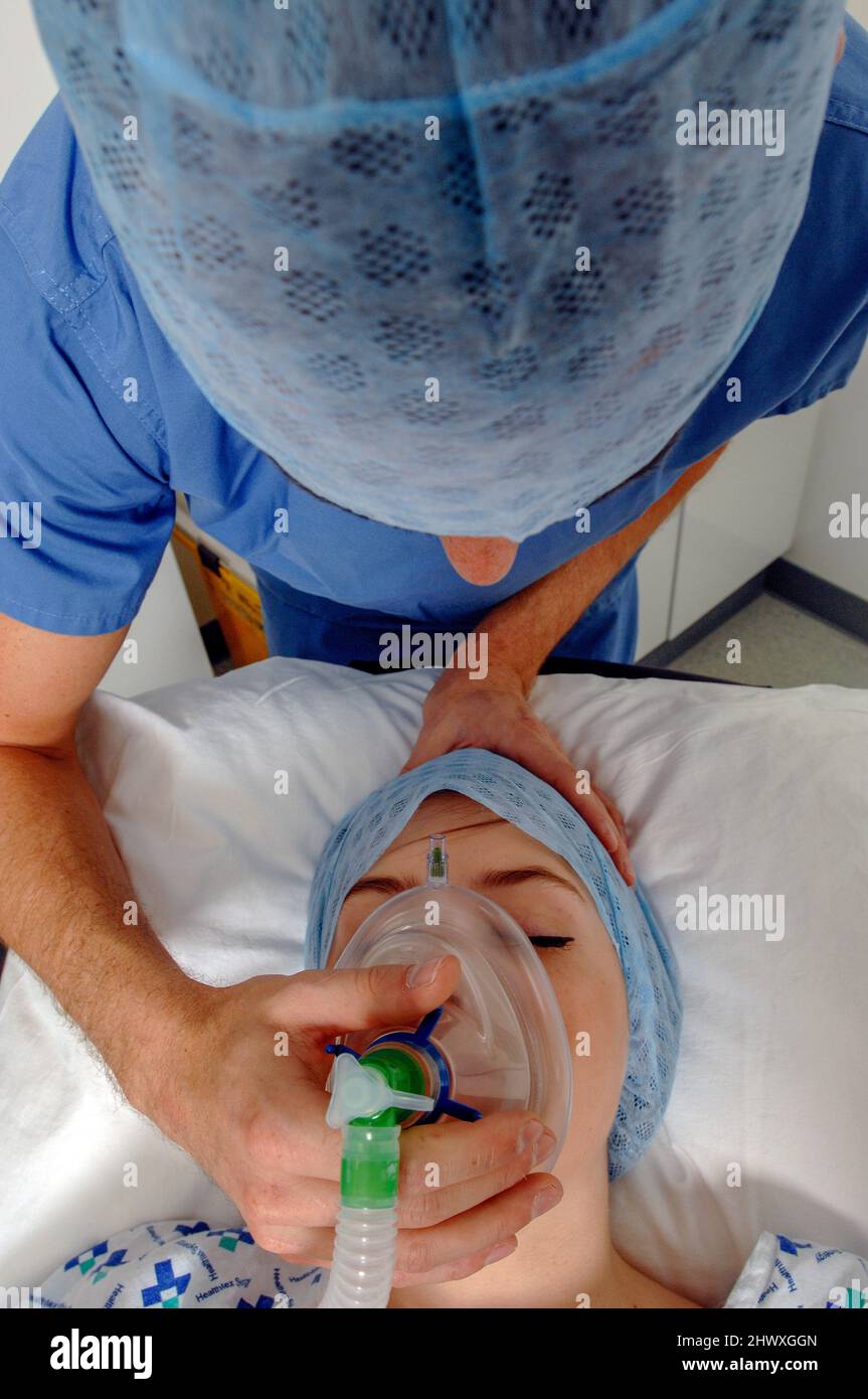 An anaesthetist administering medical gases to put a patient to sleep ...