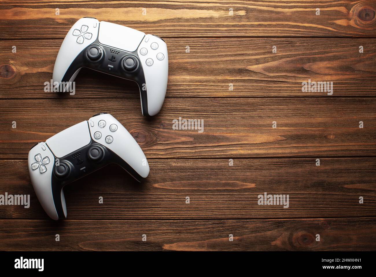 Two dualsense ps5 controllers on wooden background, gaming concept ...