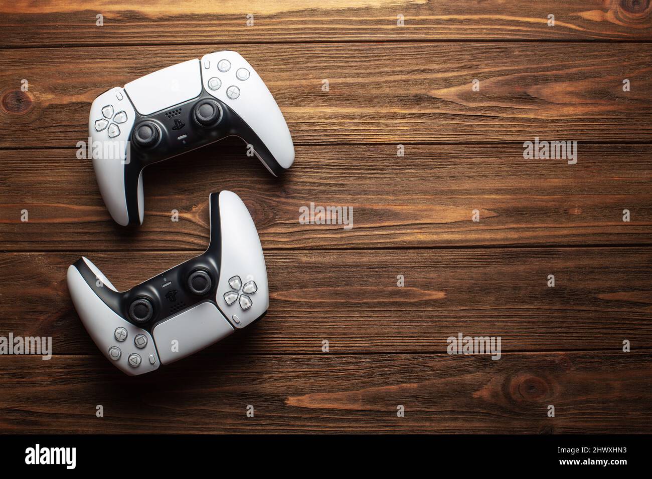 Two dualsense ps5 controllers on wooden background, gaming concept ...