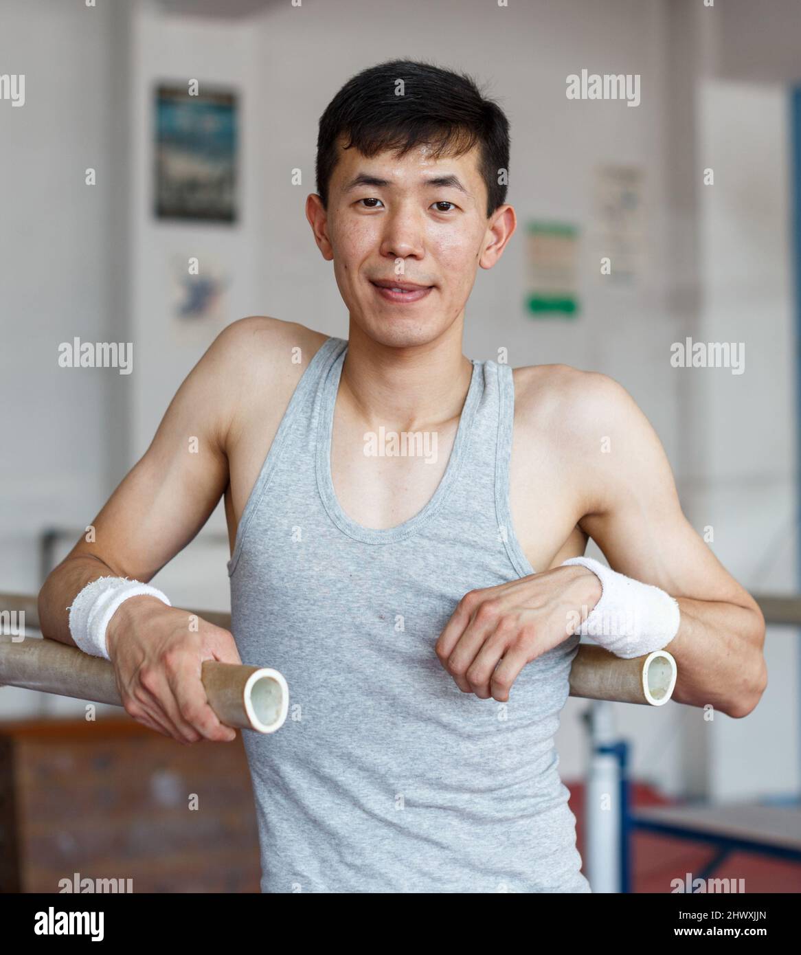Smiling young male asian acrobat posing at sport gym indoor Stock Photo ...