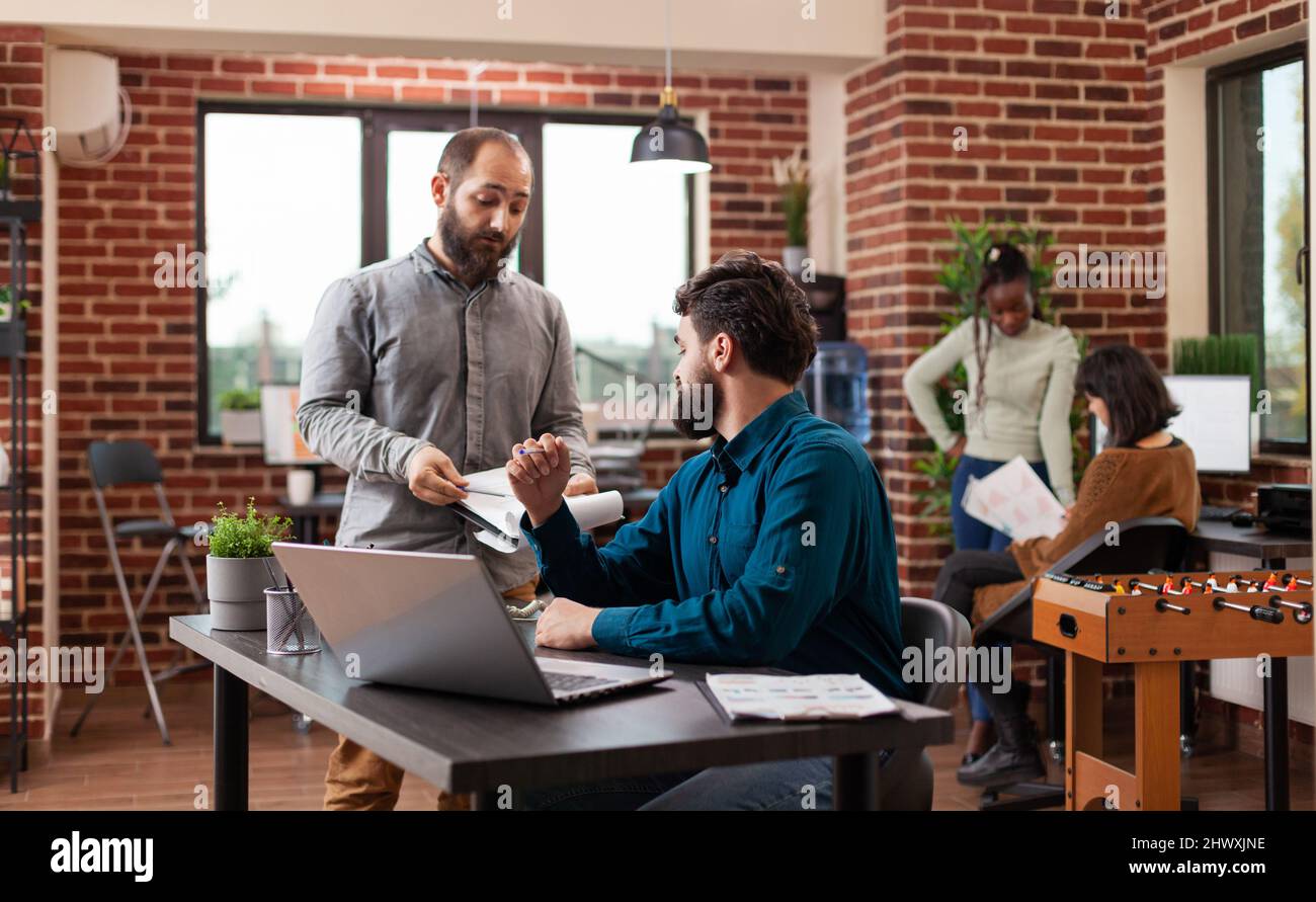 Millennial busy businessmen discussing marketing strategy analyzing ...