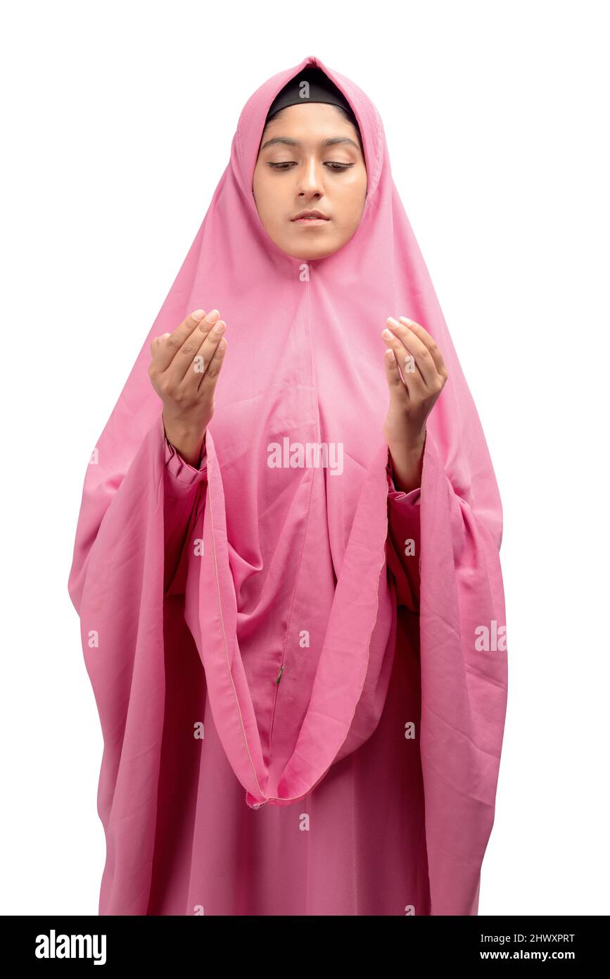 Asian Muslim woman in a veil standing while raised hands and praying ...