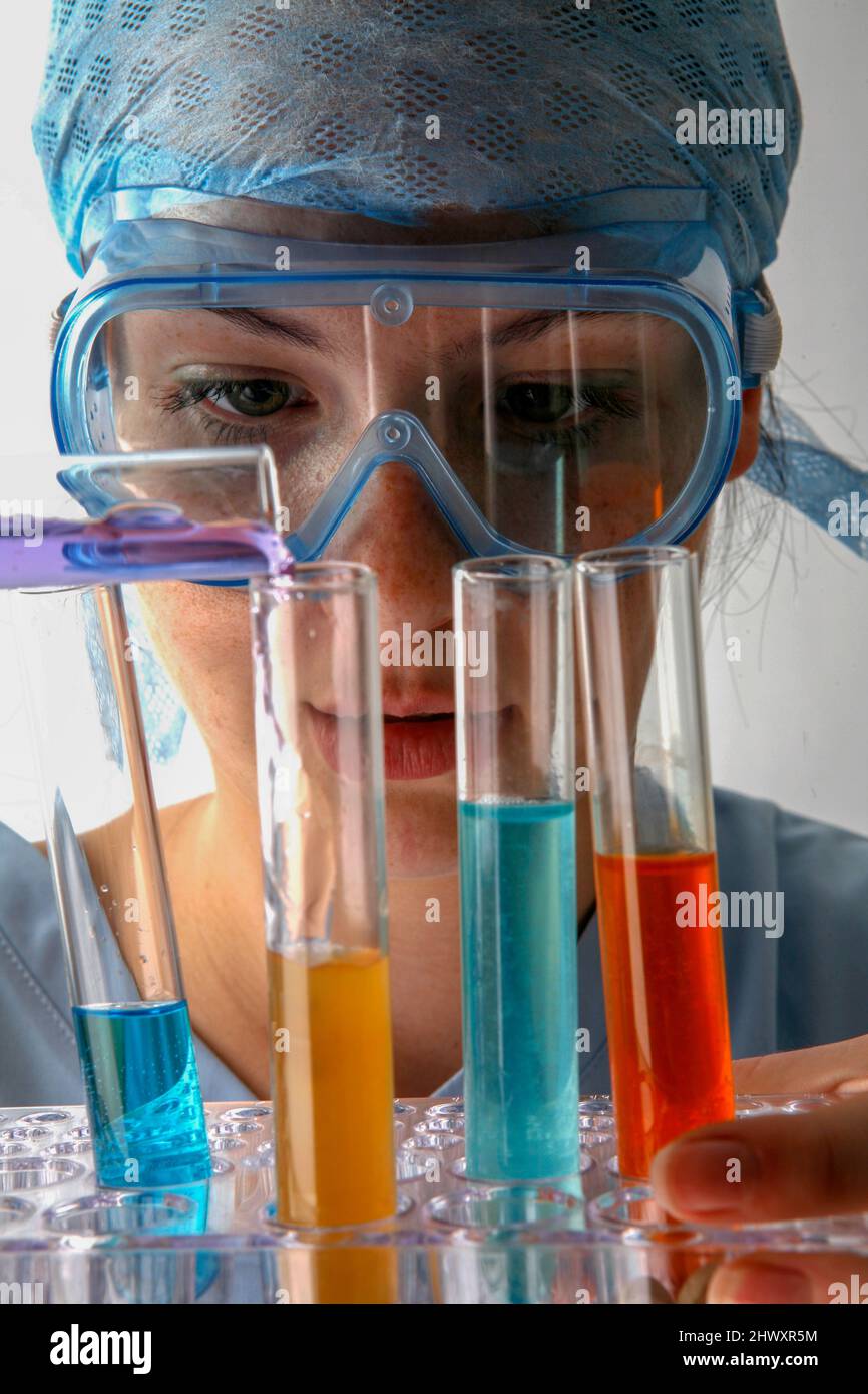 A Young Lab Technician with a number of Substances in test tubes ...