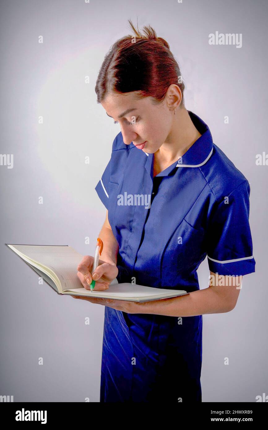 Female nurse writing up her patients notes.(MODEL RELEASED Stock Photo ...