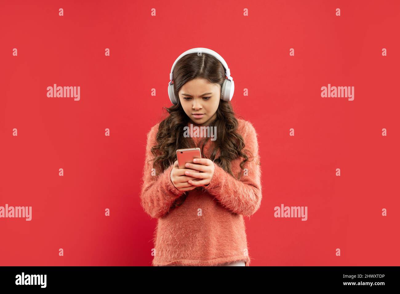 busy teen girl in earphones messaging smartphone. modern life in ...