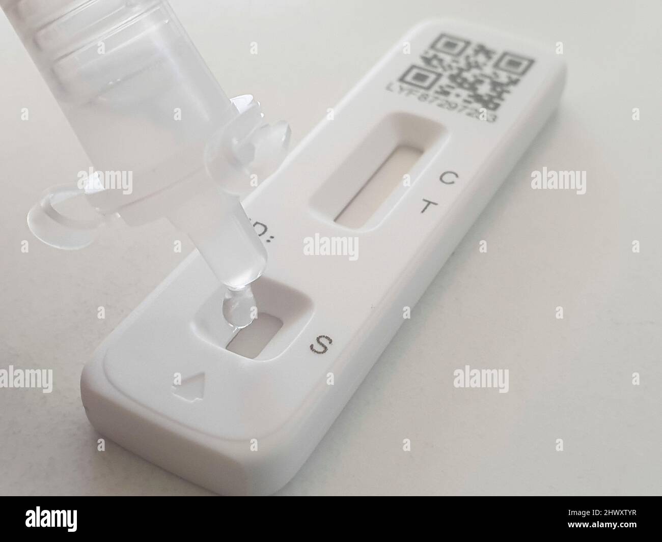 A covid swab sample in buffer solution is dropped onto the test ...