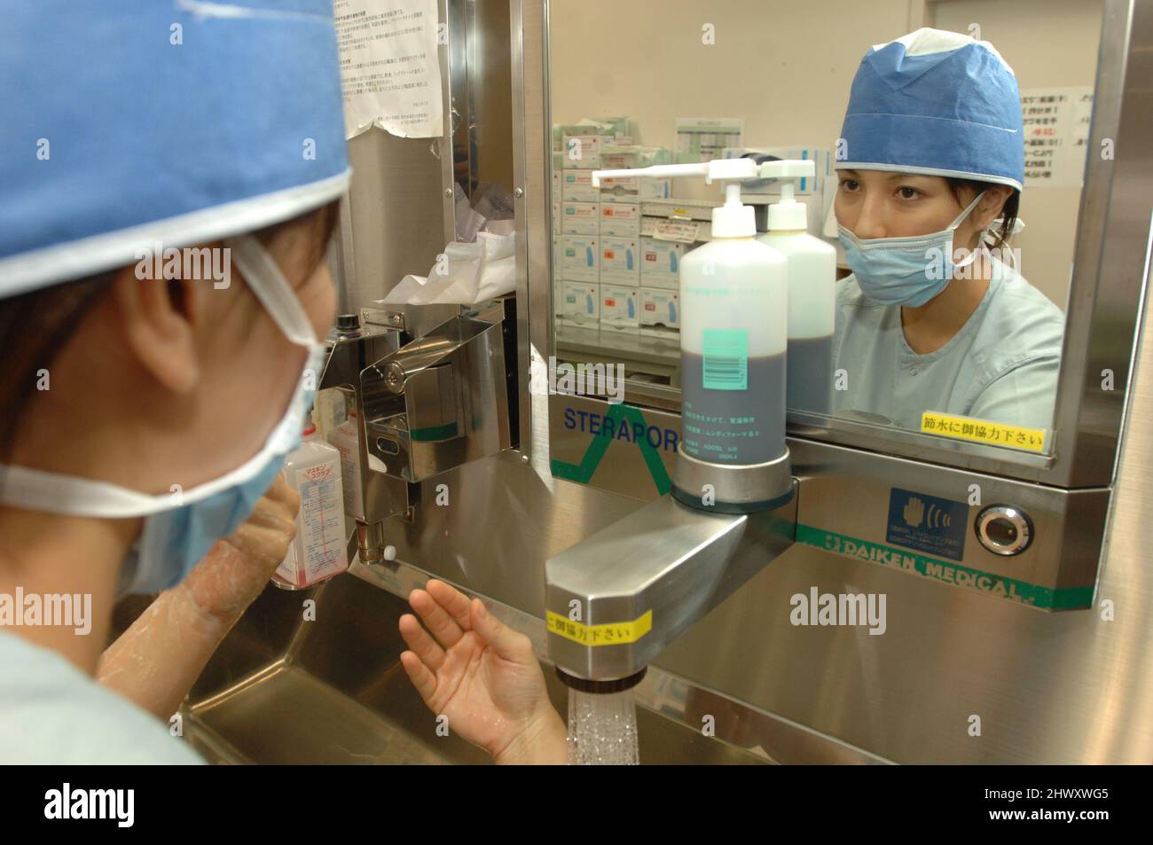 Nurse scrubbing up prior to consulting with a patient, Japanese Red ...