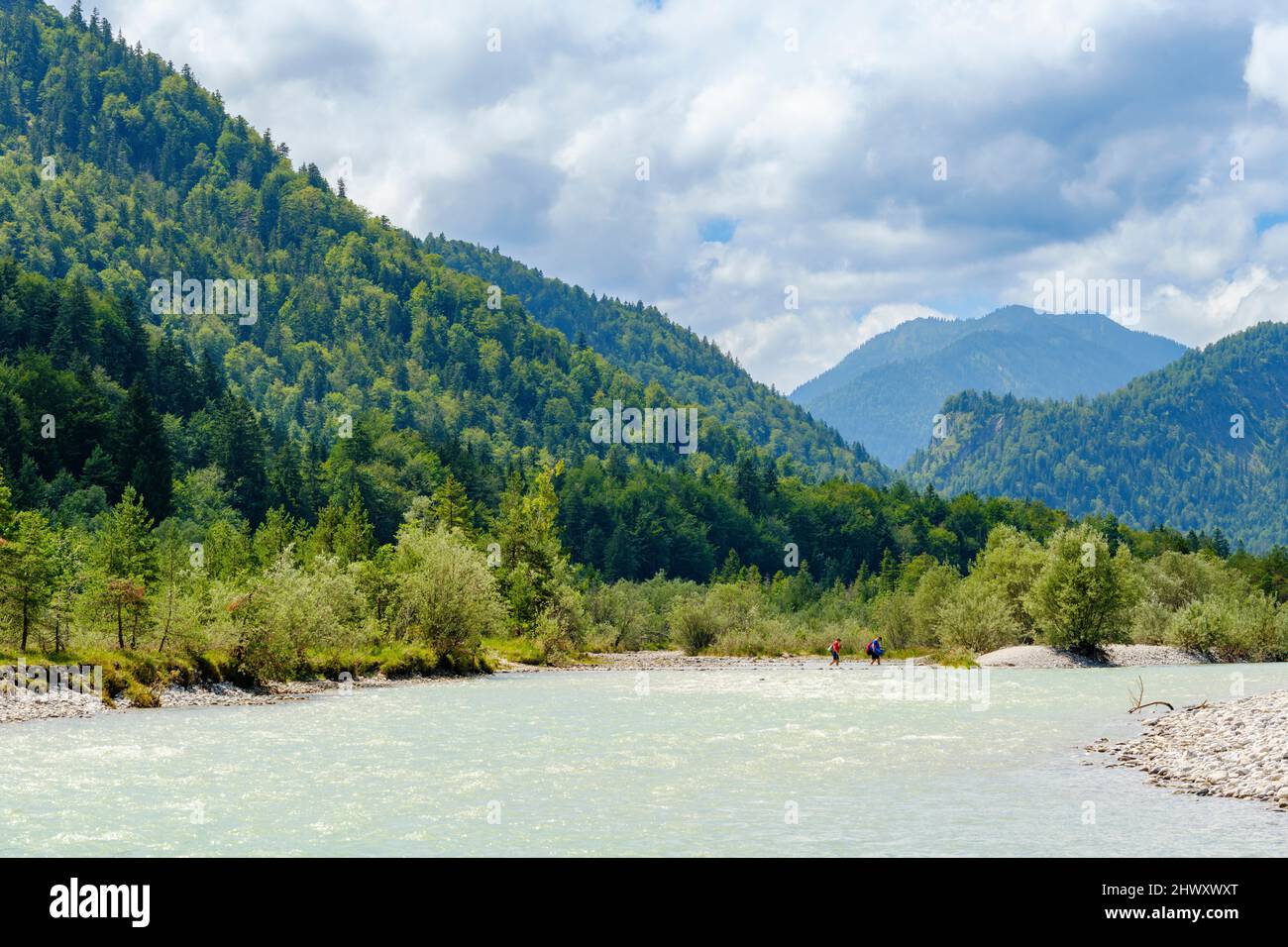 Hikers are crossing river Isar River Isar between Lenggries and Lake ...