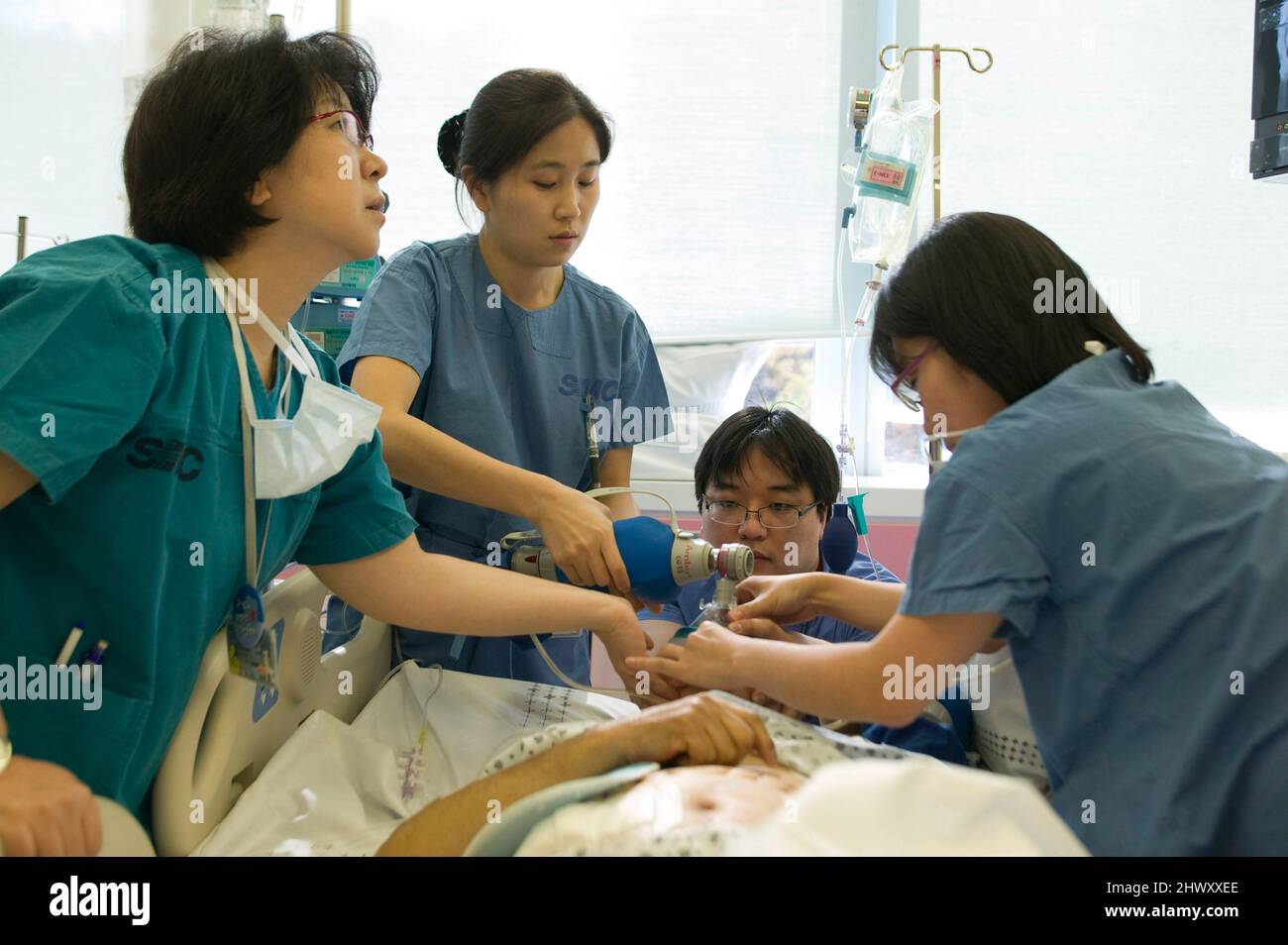Medical staff use an oxygen tank to help revive a patient from general ...