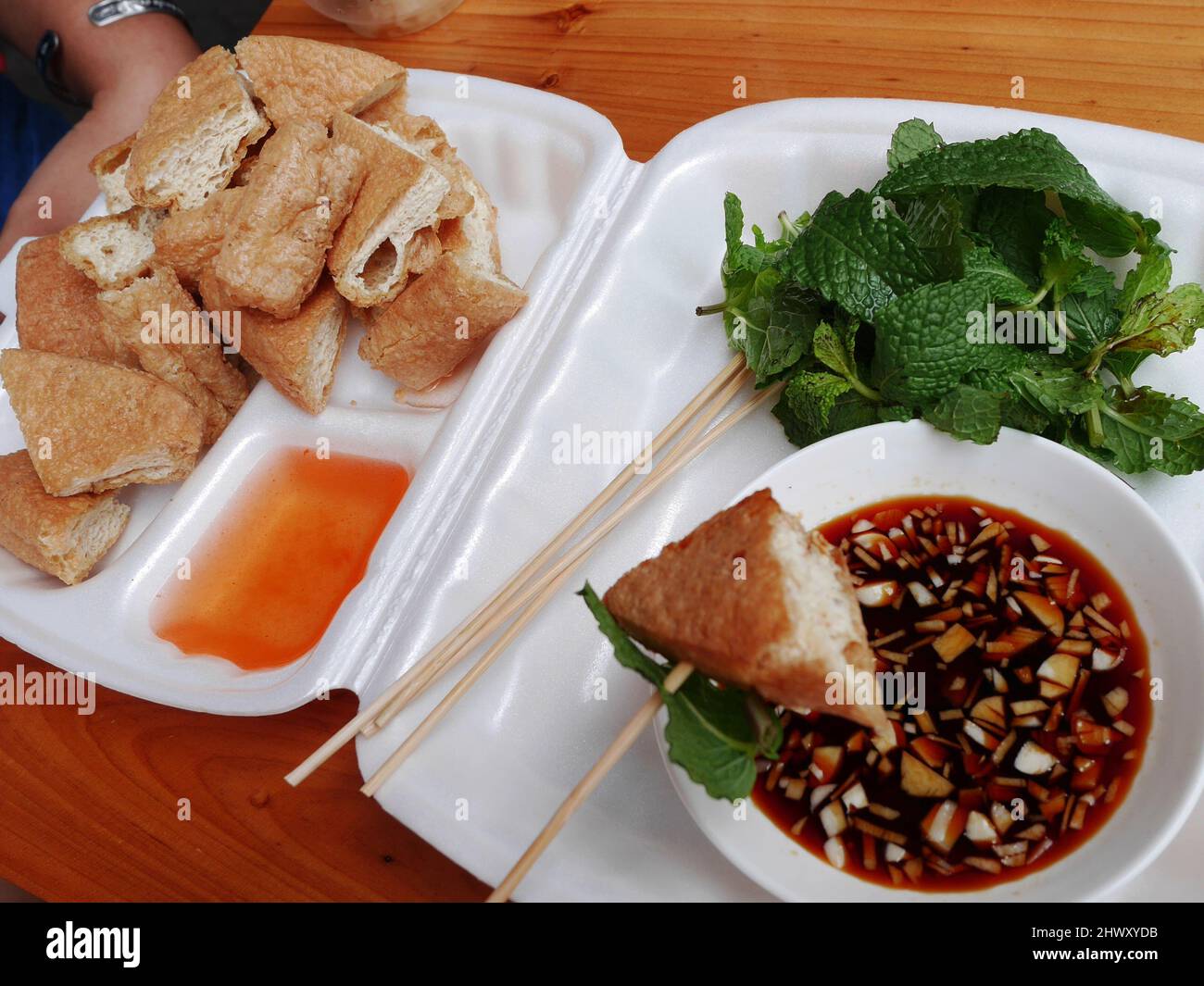 Chinese people and foreign travelers buy and eat fried tofu with ...