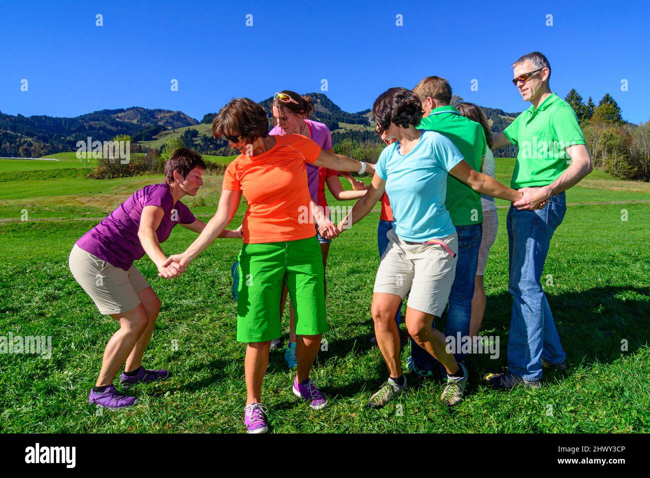 Funny and tricky knot game during team training Stock Photo - Alamy