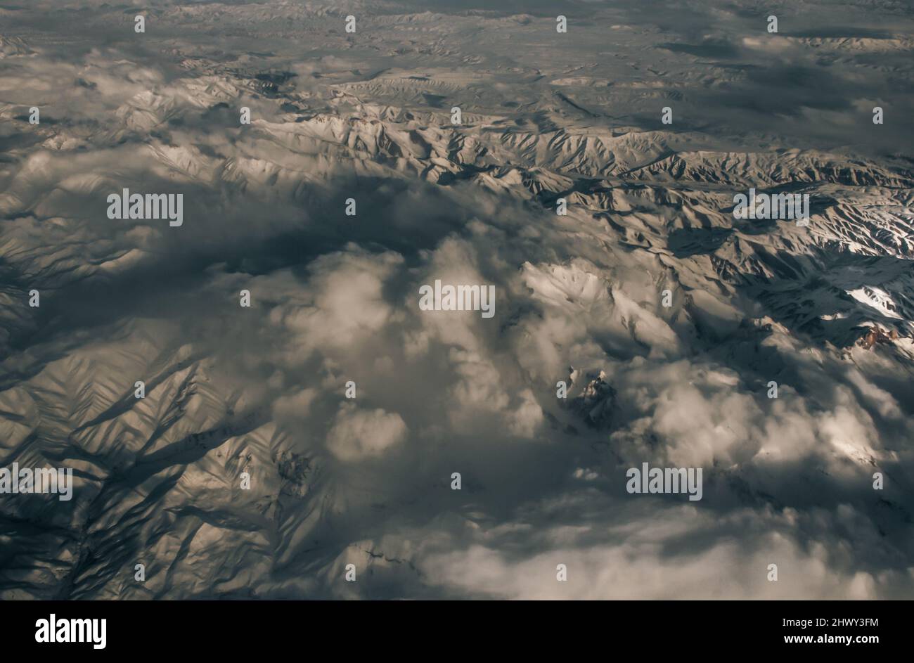 Aerial view from the plane of hills snow and mountains landscape with ...