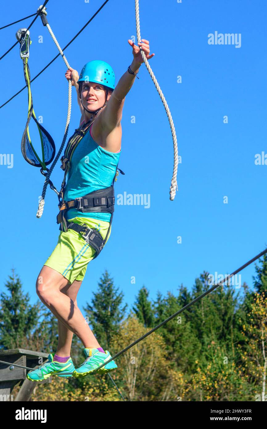 Balancing exercise in high ropes course Stock Photo - Alamy