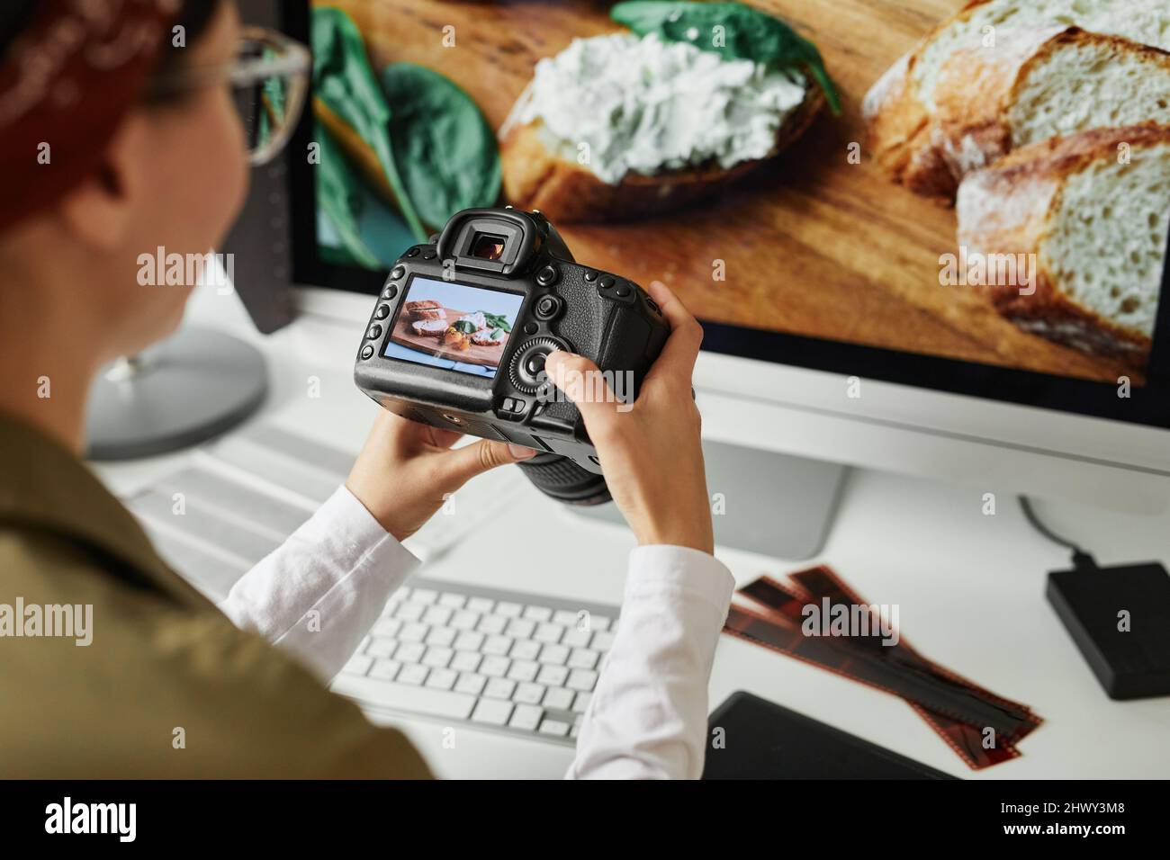 High angle view at female photographer holding camera with image on ...