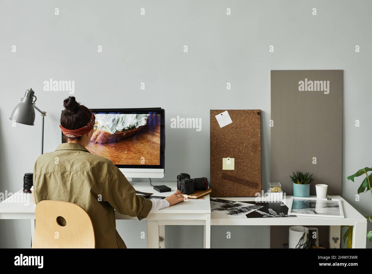 Minimal back view of female photographer editing photos at workplace in ...