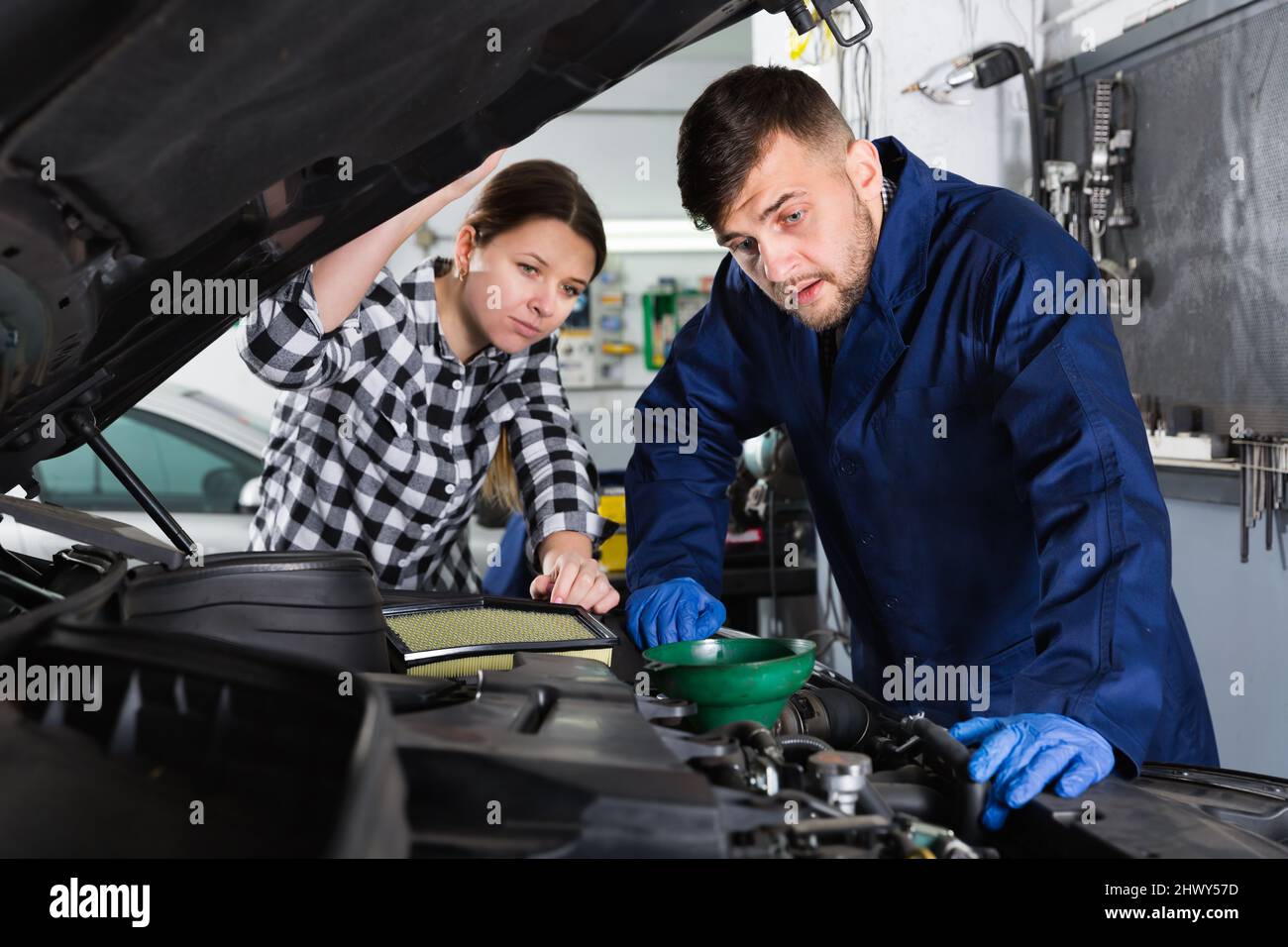 Female master with foreman are replacing the oil in car Stock Photo - Alamy