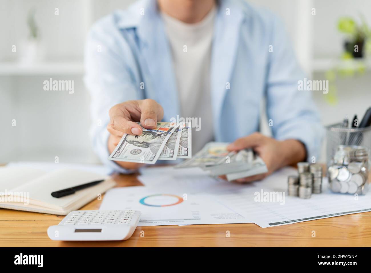 Saving concept the male money collector arranging his cash and coins on ...